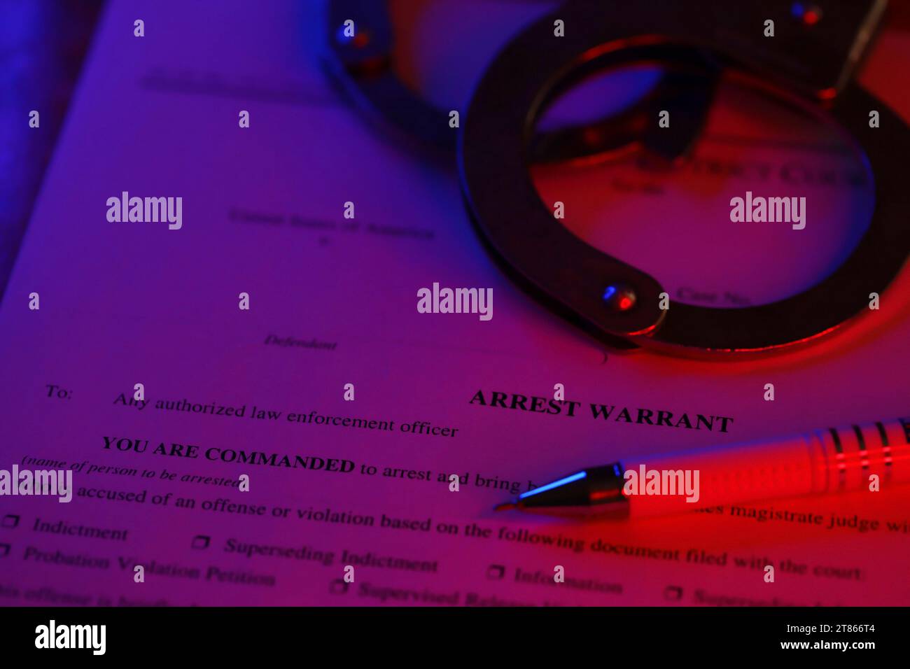 District Court Arrest Warrant court papers with handcuffs and blue pen ...