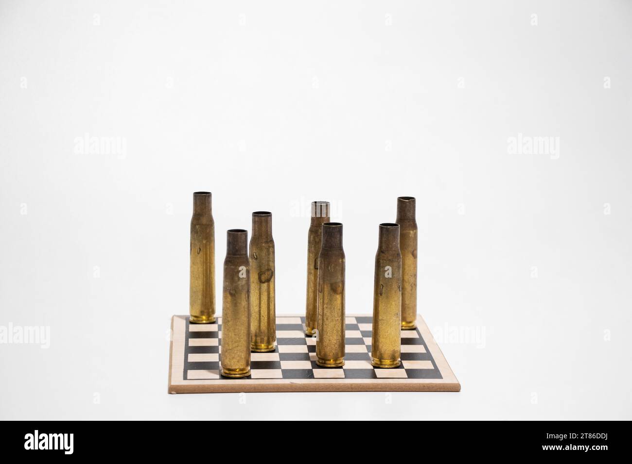 Blank rifle casing on a chessboard on a white background, weapons and ...