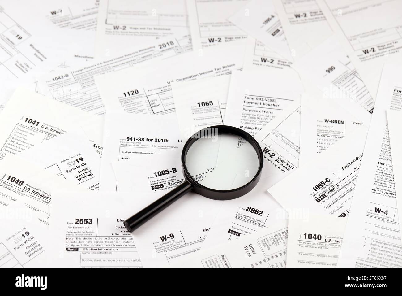 Magnifying glass lying over heap of paper documents. Investigation and ...