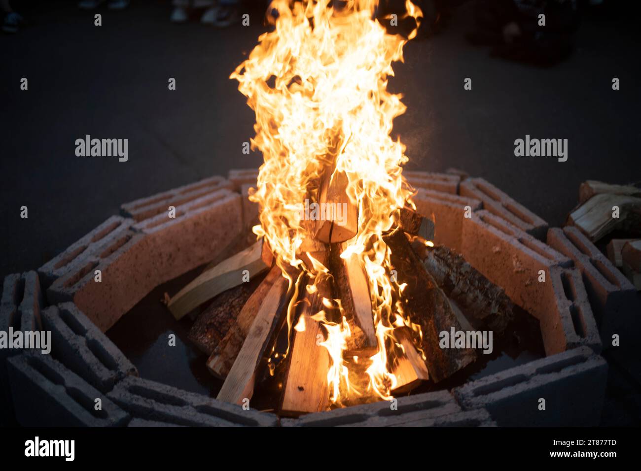 Large bonfire on street. Bonfire in evening. Concrete blocks around ...