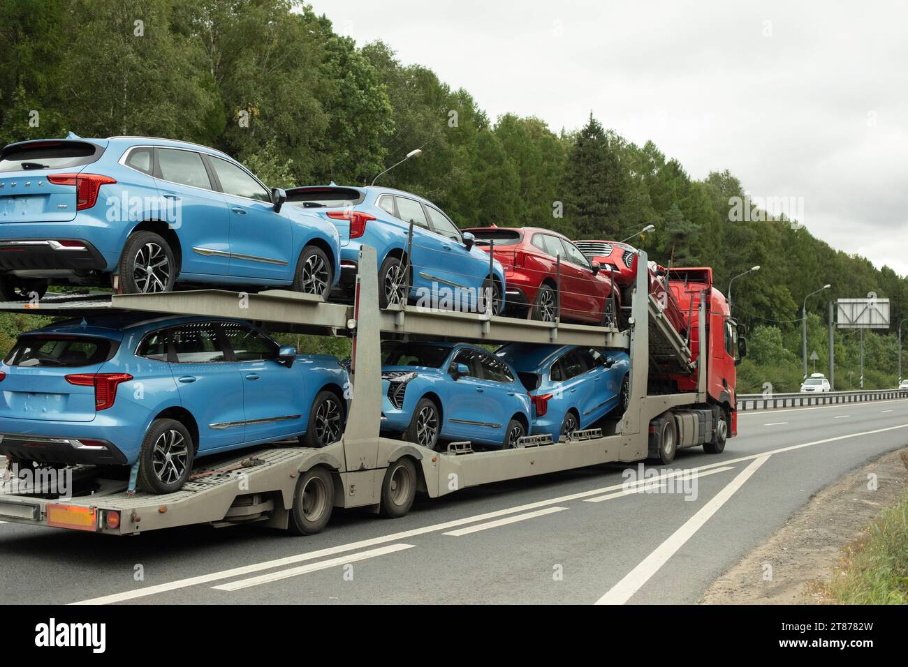 Transportation of motor vehicles. Truck carries cars on trailer ...
