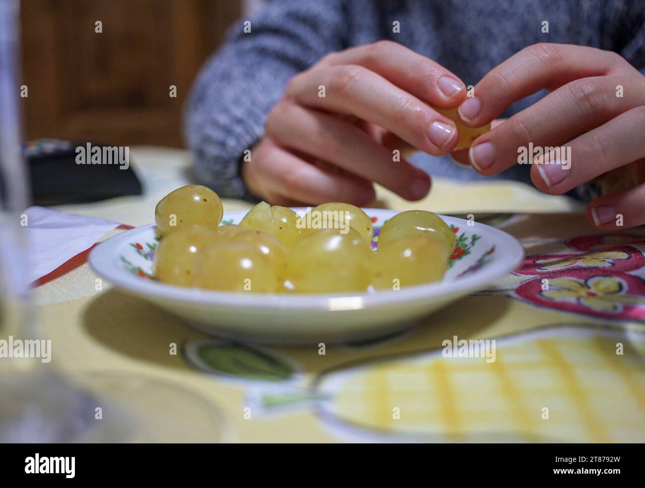 young boy having the twelve grapes of good luck in the first seconds of ...