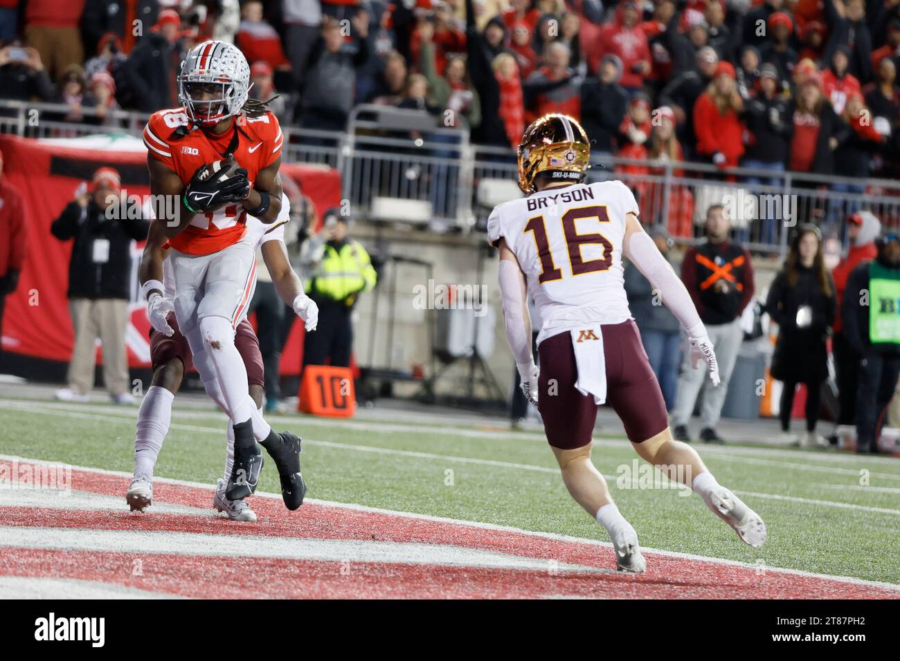 Ohio State receiver Marvin Harrison, left, scores a touchdown as Minnesota defensive back ...