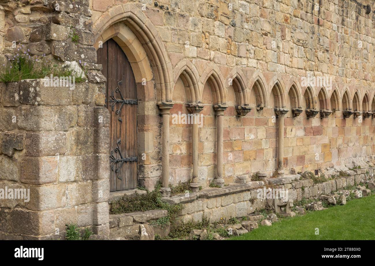 Ancient wooden arched doorway and arches in the side of an abbey Stock ...
