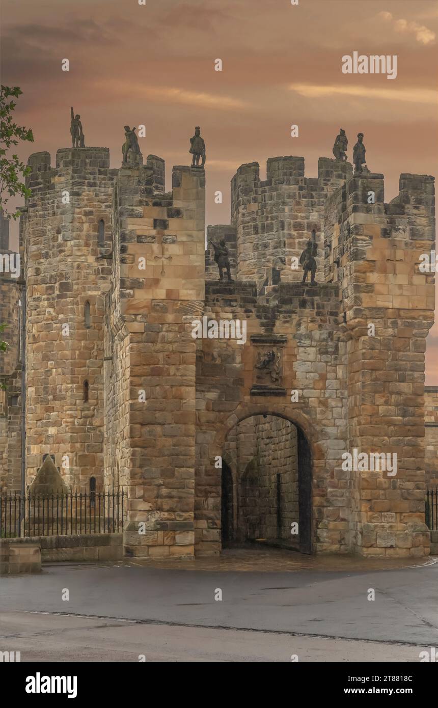 The entrance to a castle with ornate statues on top ramparts with a ...