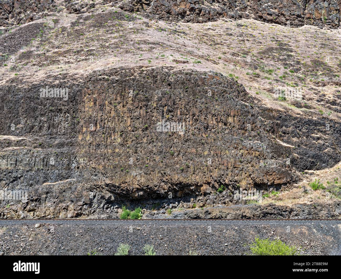 Railroad tracks run below the basalt cliffs of the Deschutes River near ...