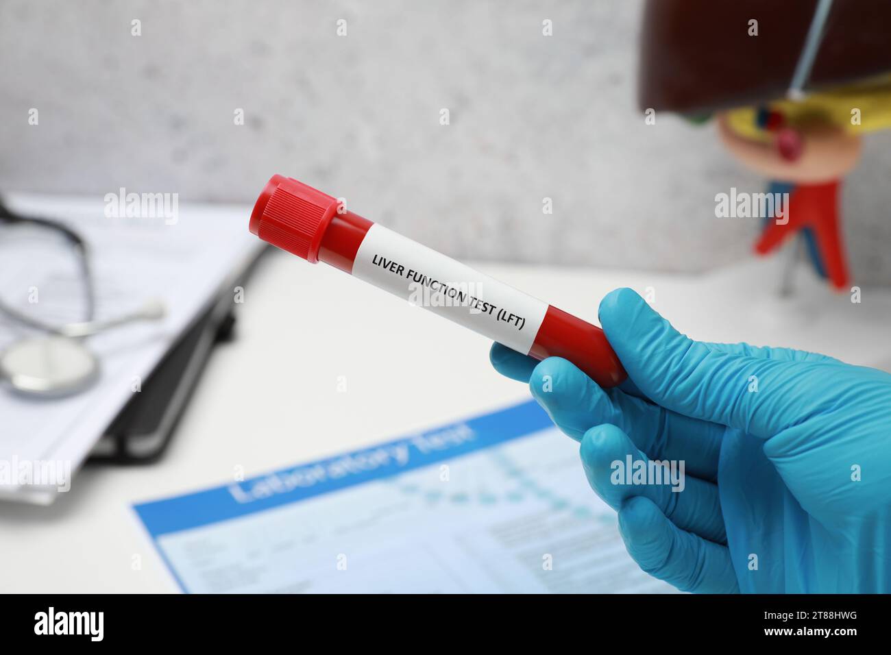 Laboratory worker holding tube with blood sample and label Liver ...