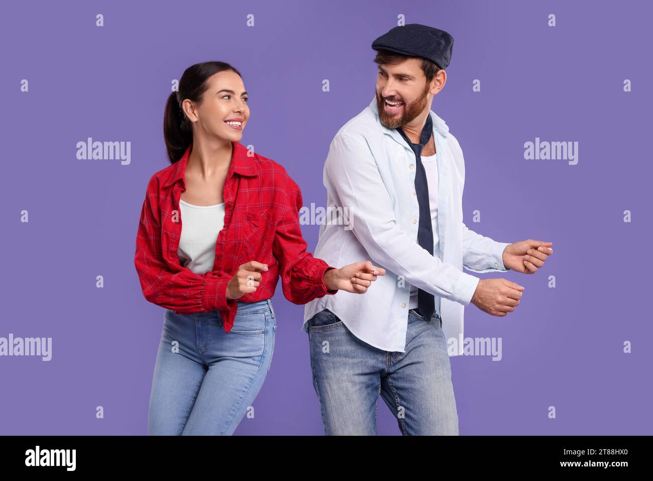 Happy couple dancing together on violet background Stock Photo - Alamy