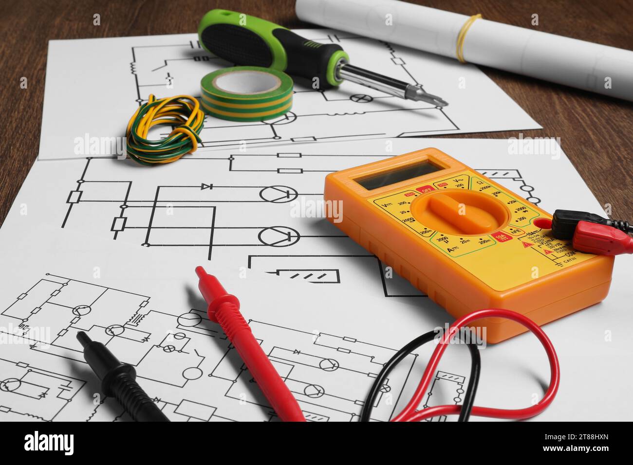Wiring diagrams, digital multimeter and tools on wooden table, closeup ...