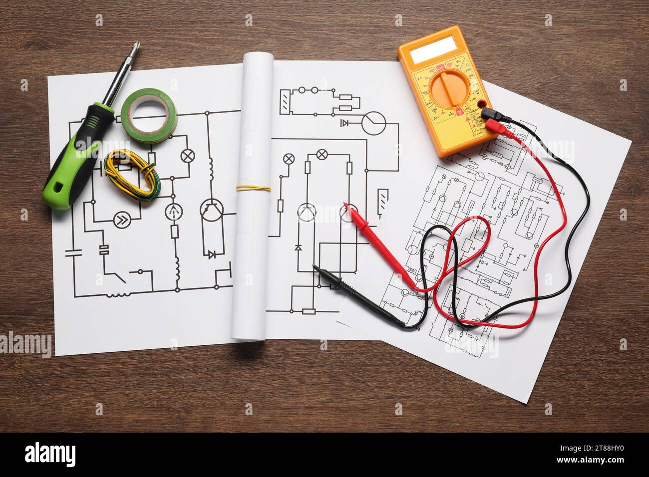 Wiring diagrams, digital multimeter and tools on wooden table, top view ...
