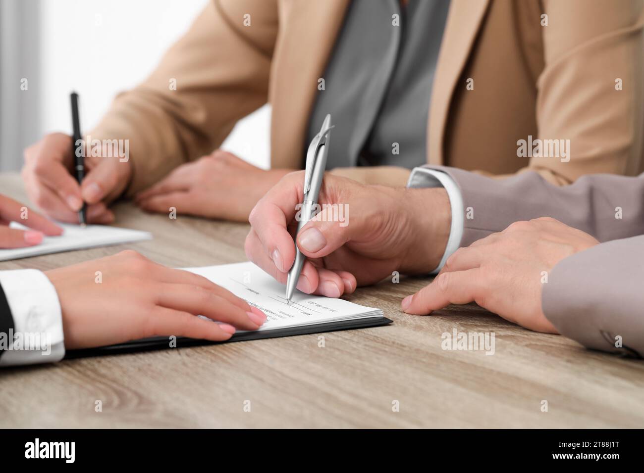Manager showing client where he must to mark signature at light wooden ...