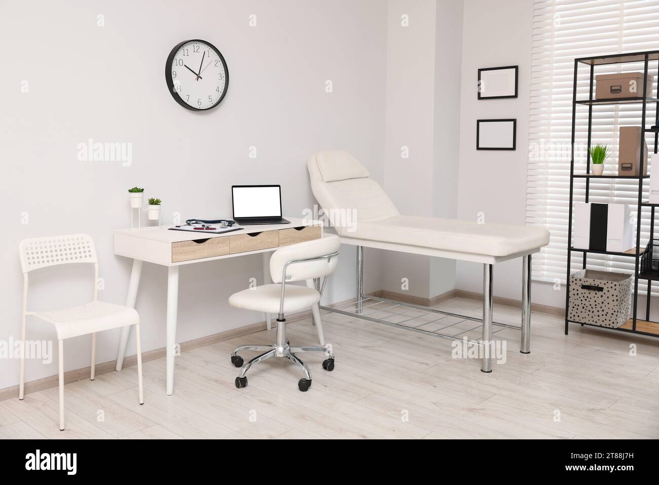 Modern medical office with doctor's workplace and examination table in ...