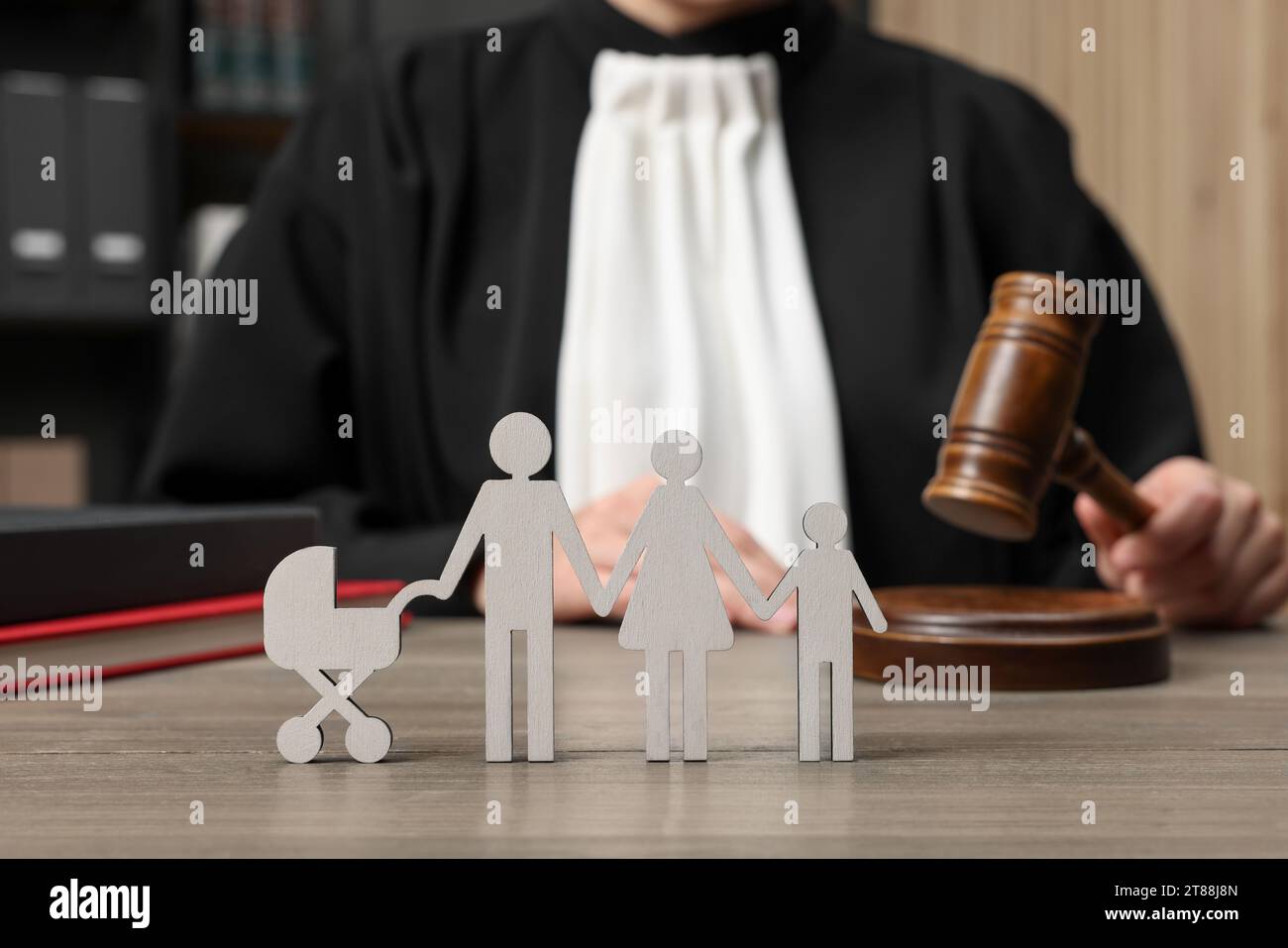 Family law. Judge with gavel sitting at wooden table, focus on figure ...