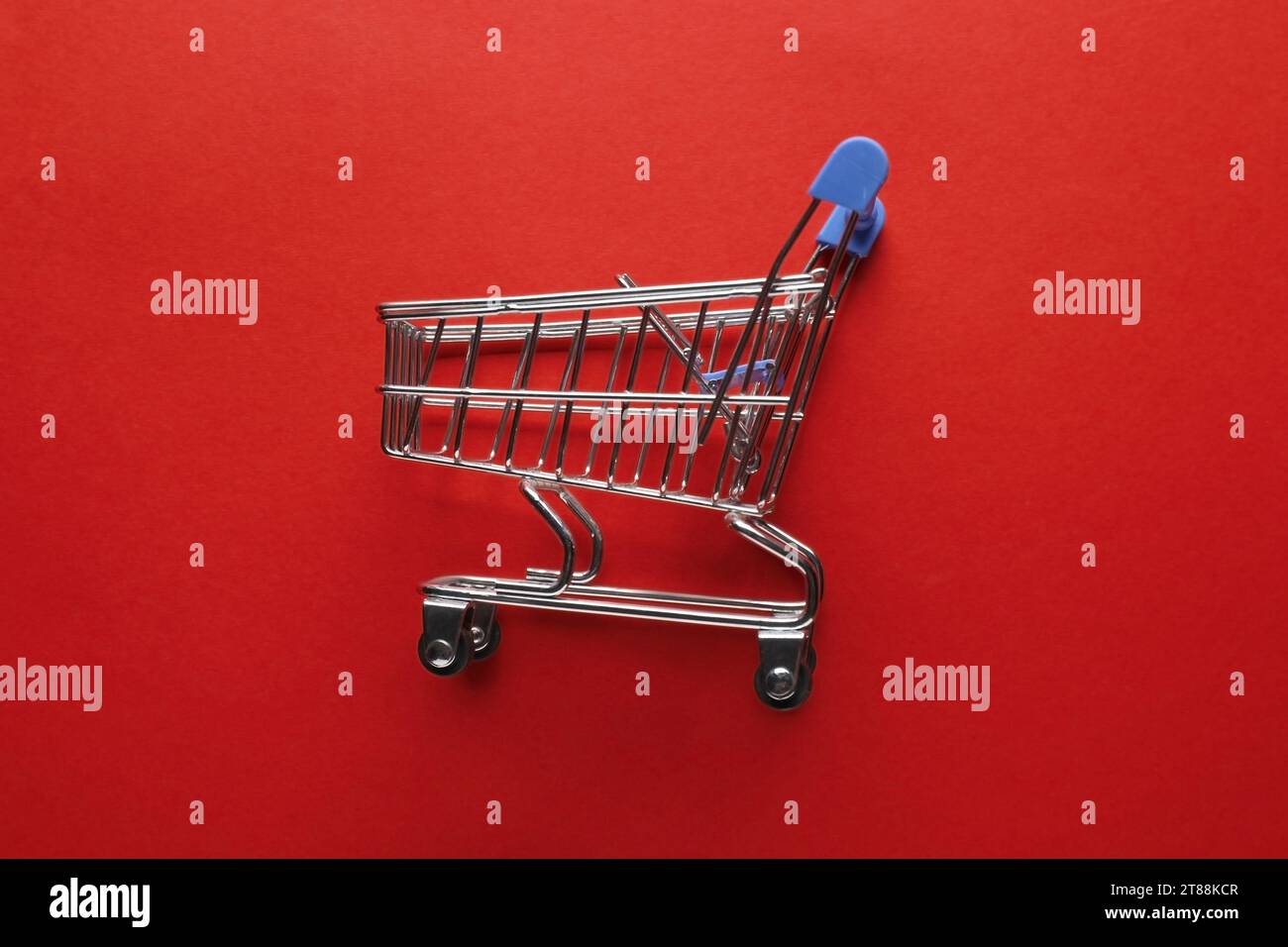 Small metal shopping cart on red background, top view Stock Photo - Alamy