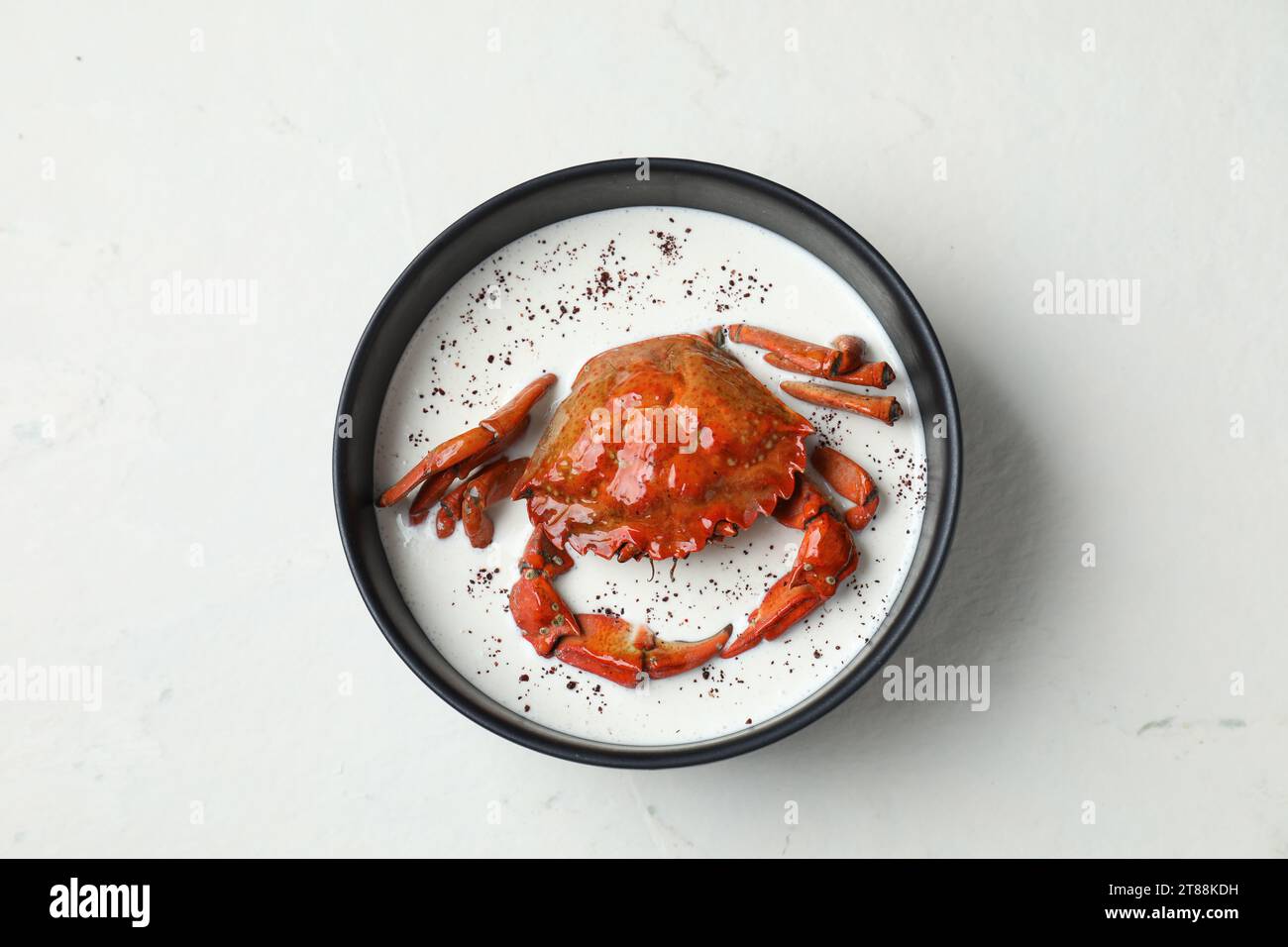 Delicious boiled crab with cream sauce in bowl on white table, top view Stock Photo - Alamy