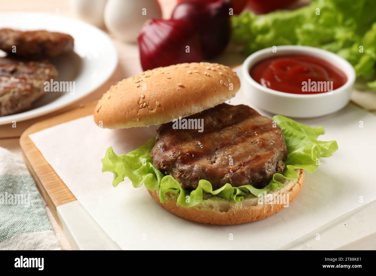 Delicious fried patty, lettuce, buns and sauce on table. Making ...