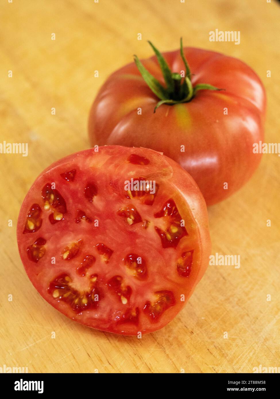 Fresh produce, juicy red tomatoes, one sliced in half showing flesh and ...