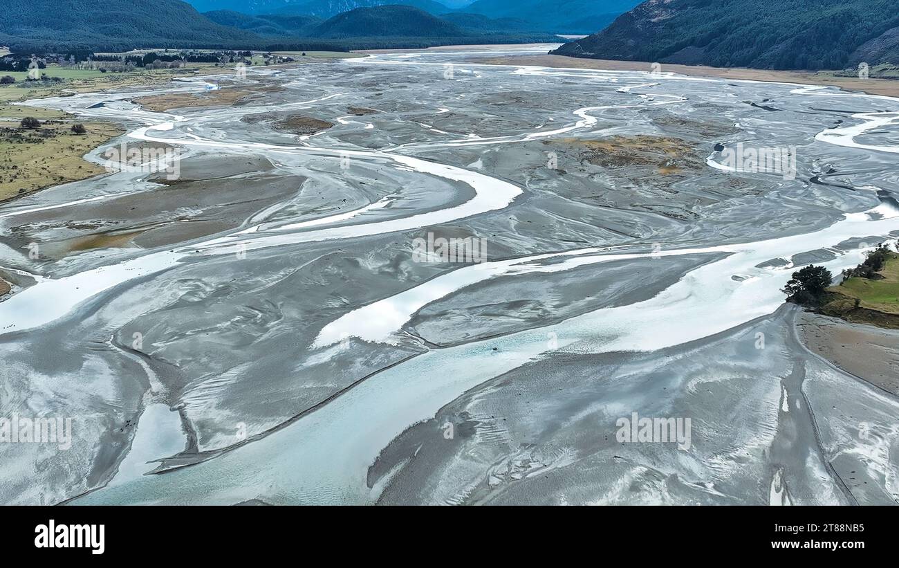Aerial drone scenery of the braided Dart river flowing through a rural ...