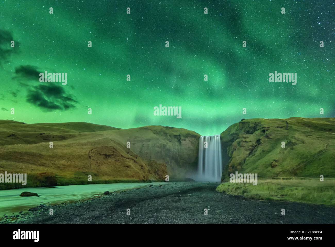 The Northern lights, aurora borealis, above the waterfall at Skogafoss ...