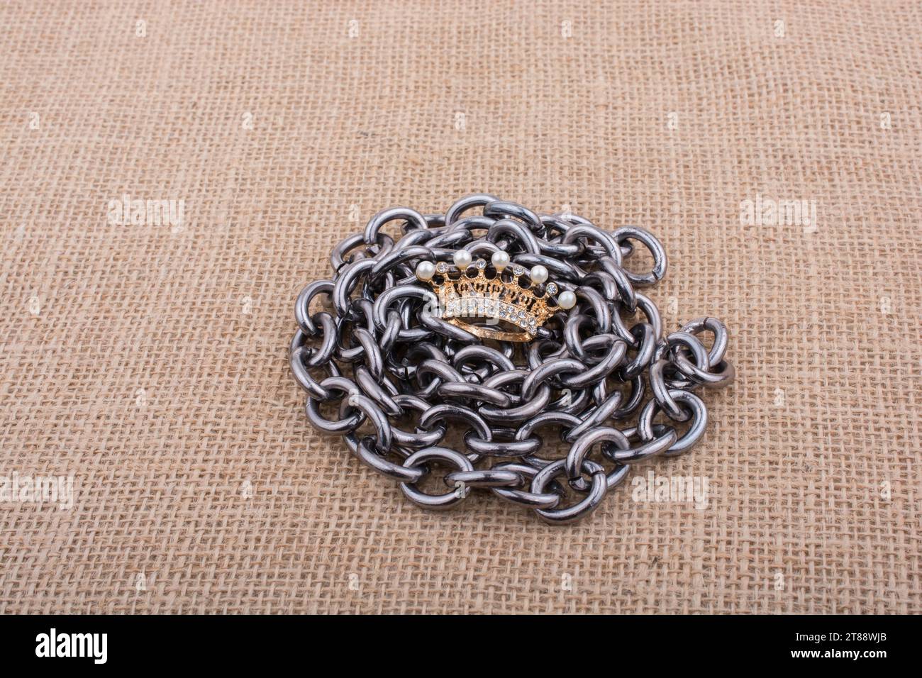 Little model crown placed on metal chain Stock Photo - Alamy
