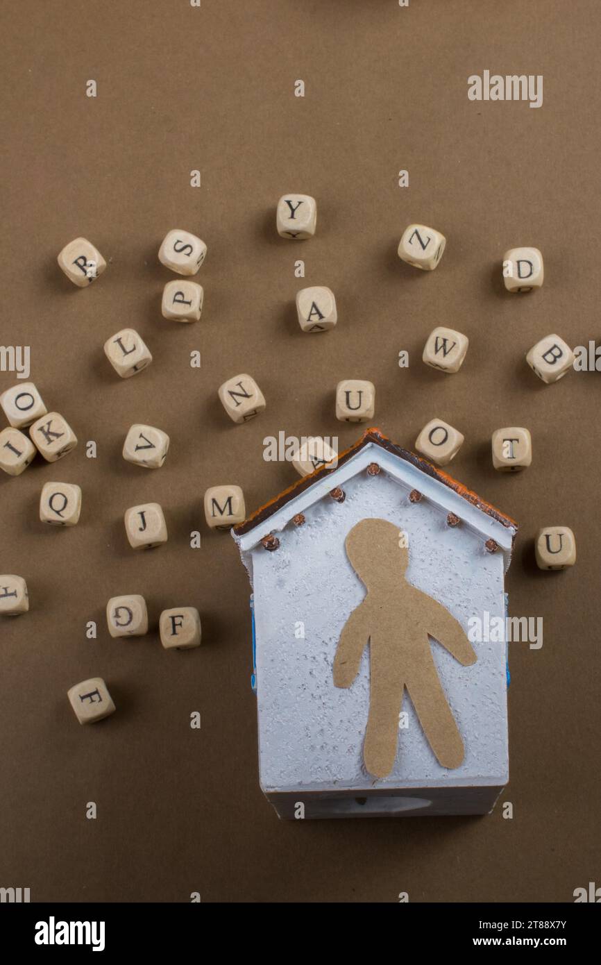 Wooden letter cubes and man figurine and model house Stock Photo - Alamy
