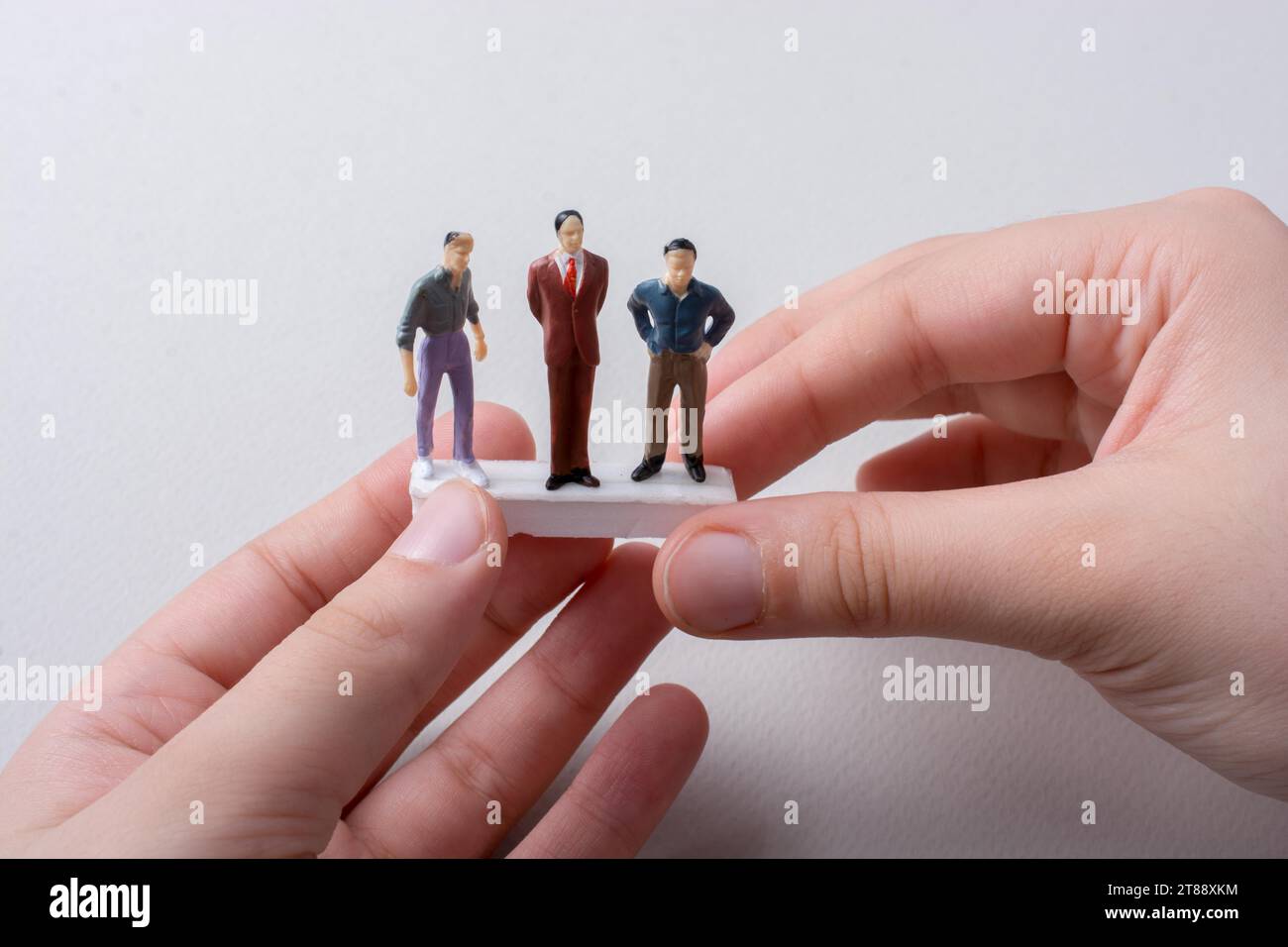 Tiny figurines of men miniature model in hand Stock Photo - Alamy