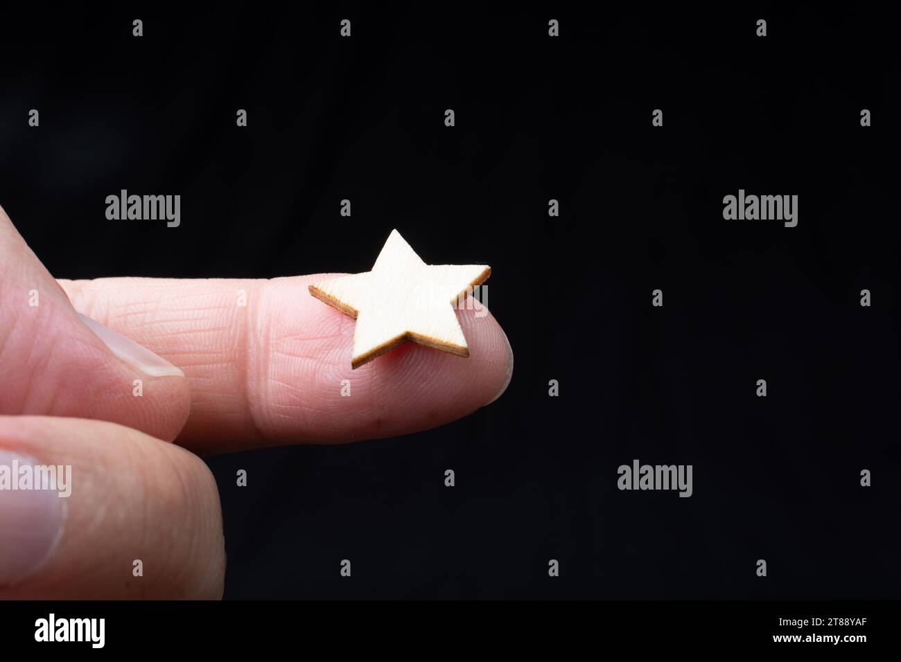 The hand holding a wooden star Stock Photo - Alamy