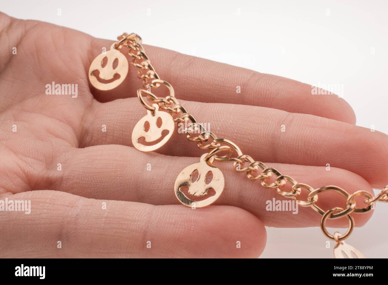 Golden color smileys arrayed on a chain in hand Stock Photo - Alamy