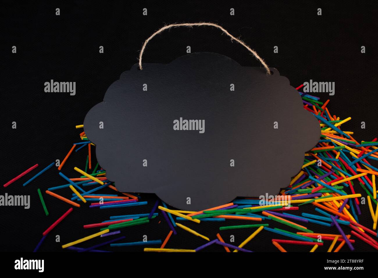 Black speech bubble shaped notice board on colorful sticks on black ...