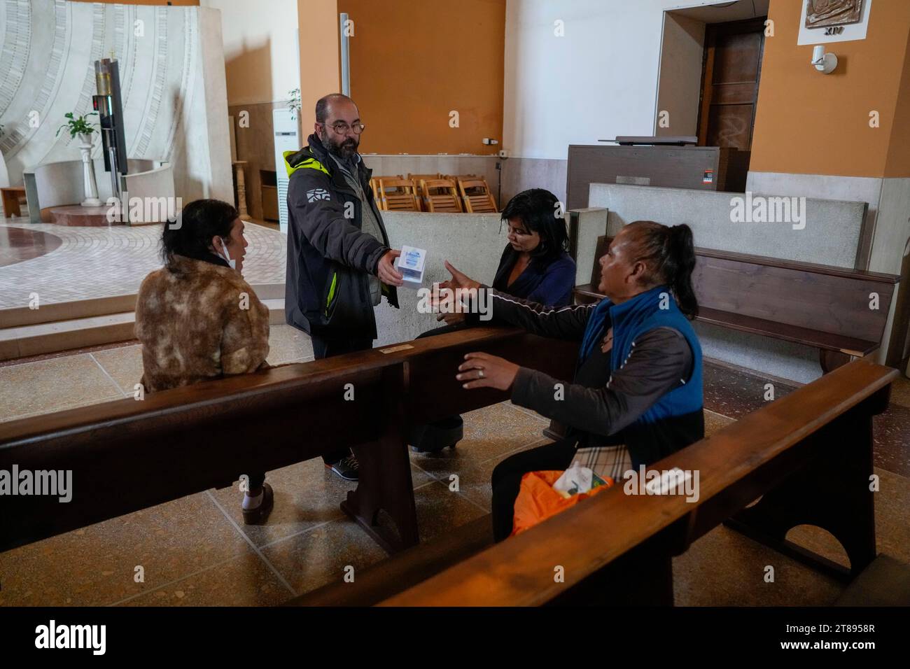 Priest Andrea Conocchia, second from left, hands over personal hygiene ...