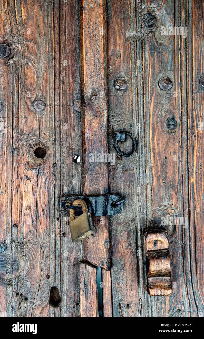 Old wooden door with an iron lock and a bolt in the monastery of the ...