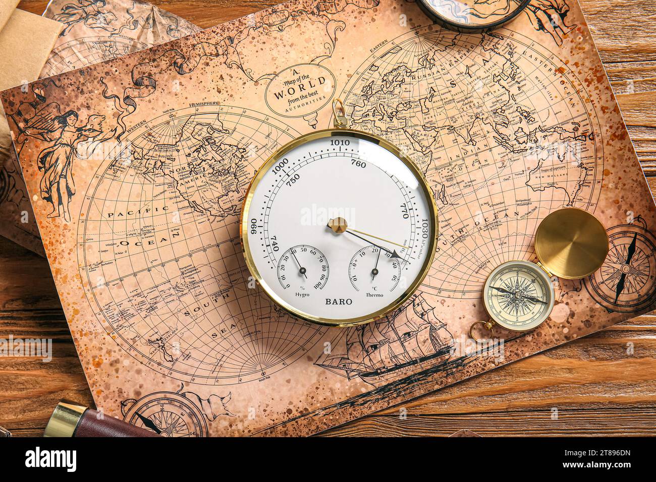 Composition with aneroid barometer and compass on world map. Sailing ...
