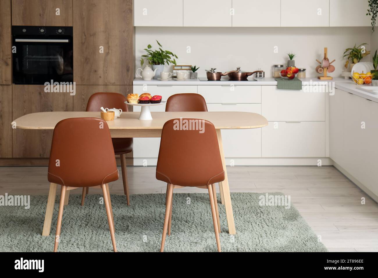 Interior of modern kitchen with wooden dining table Stock Photo - Alamy