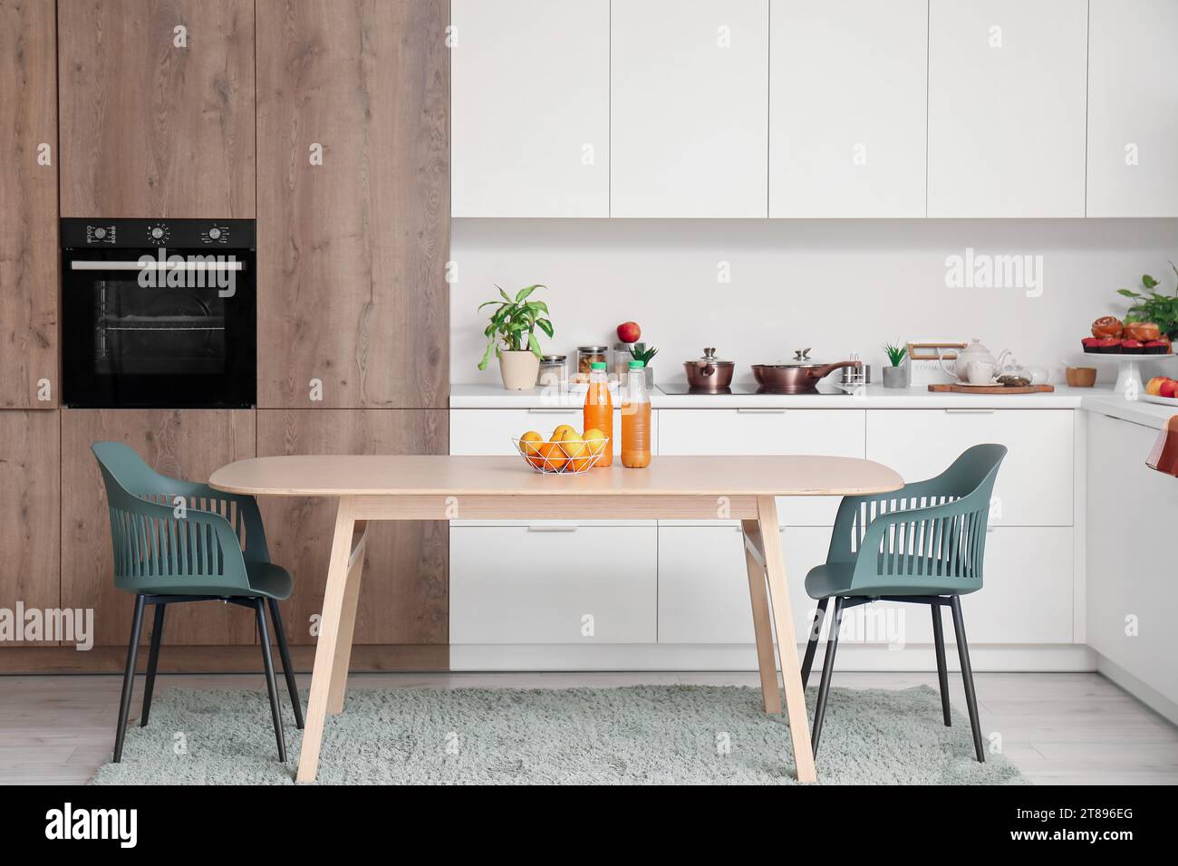 Interior of modern kitchen with wooden dining table Stock Photo - Alamy