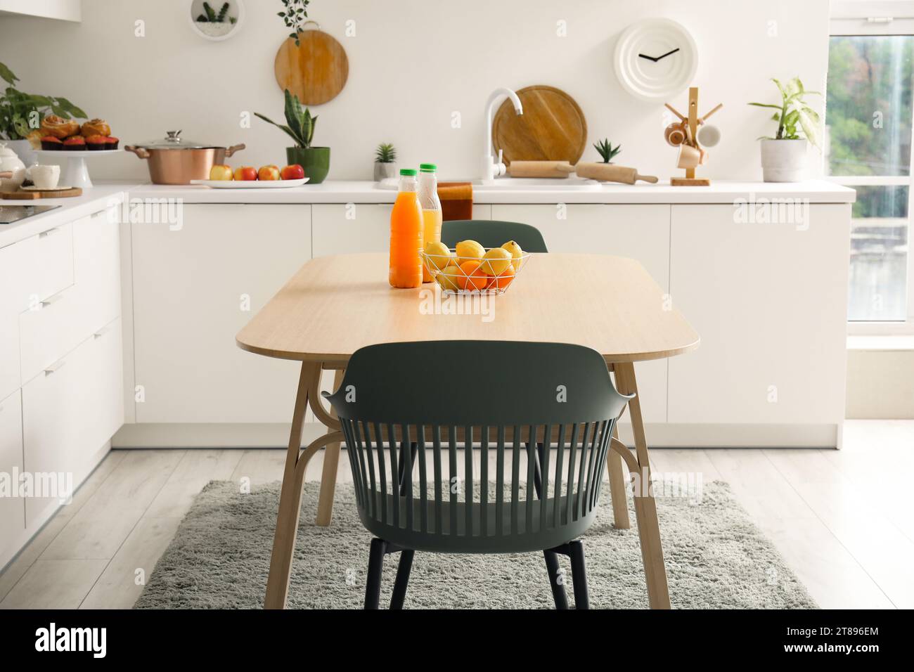 Wooden dining table with orange juice and fresh fruits in modern ...
