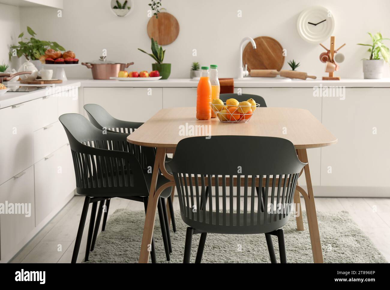 Wooden dining table with orange juice and fresh fruits in modern ...
