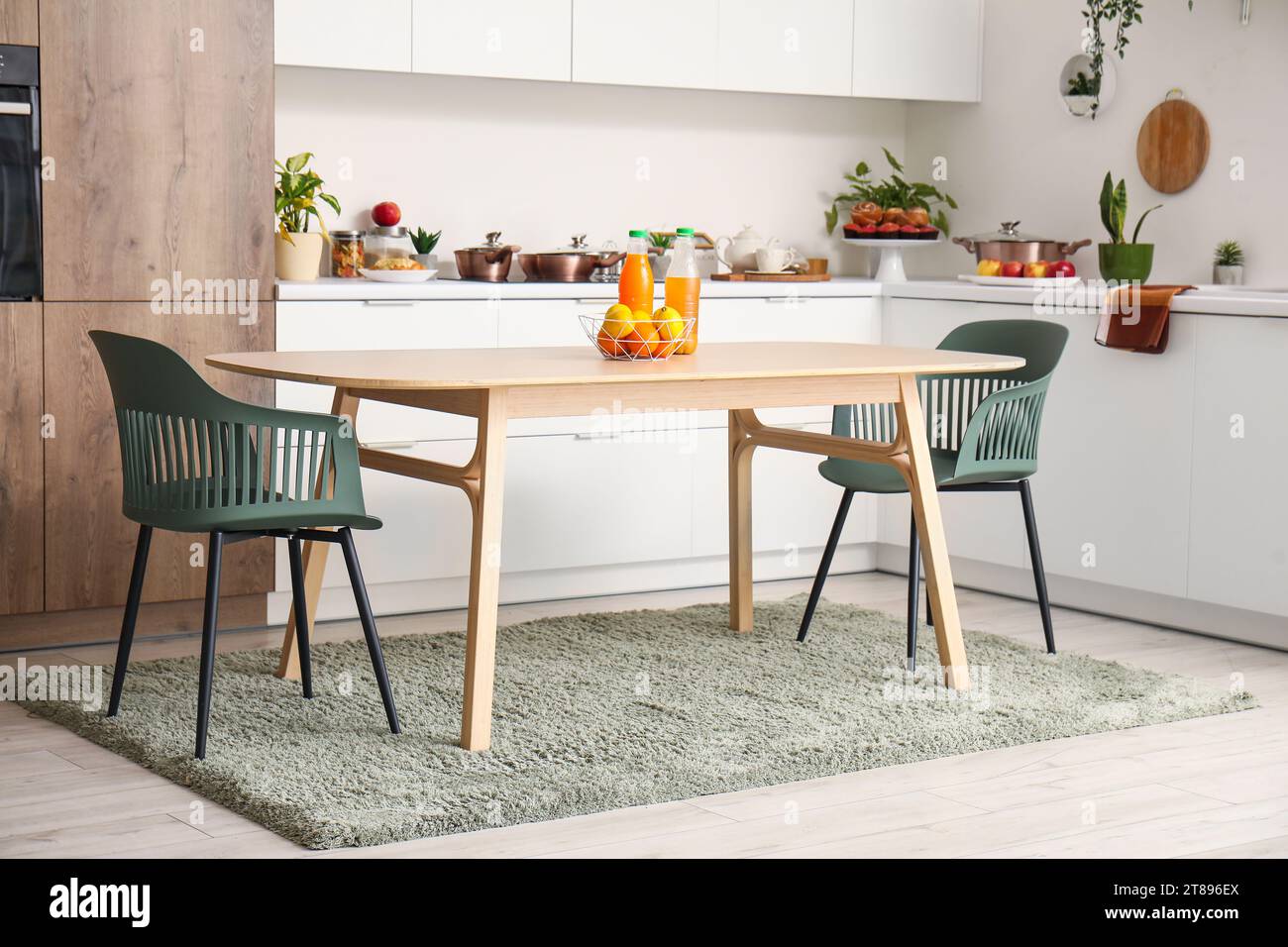 Interior of modern kitchen with wooden dining table Stock Photo - Alamy
