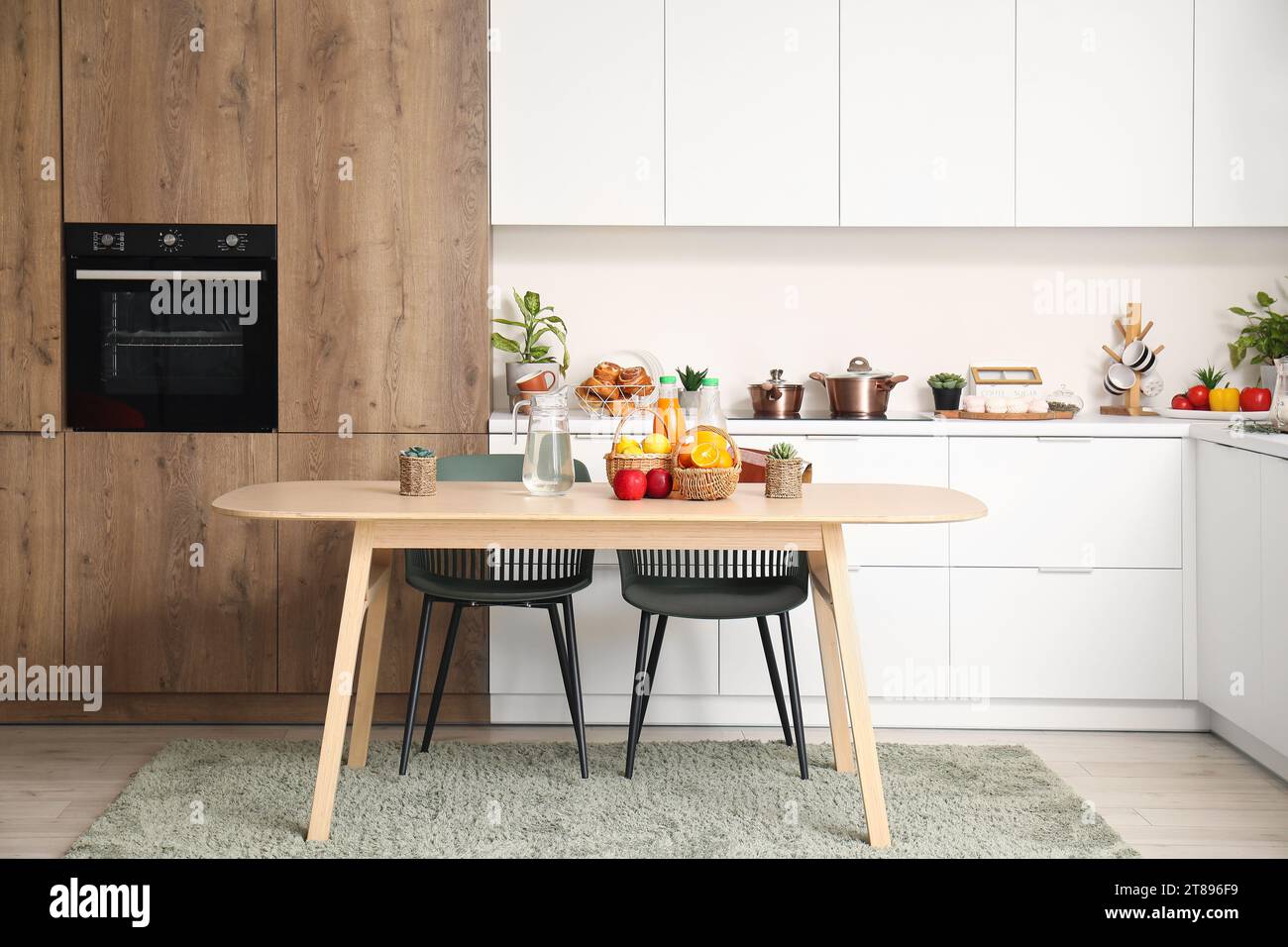 Interior of modern kitchen with wooden dining table Stock Photo - Alamy