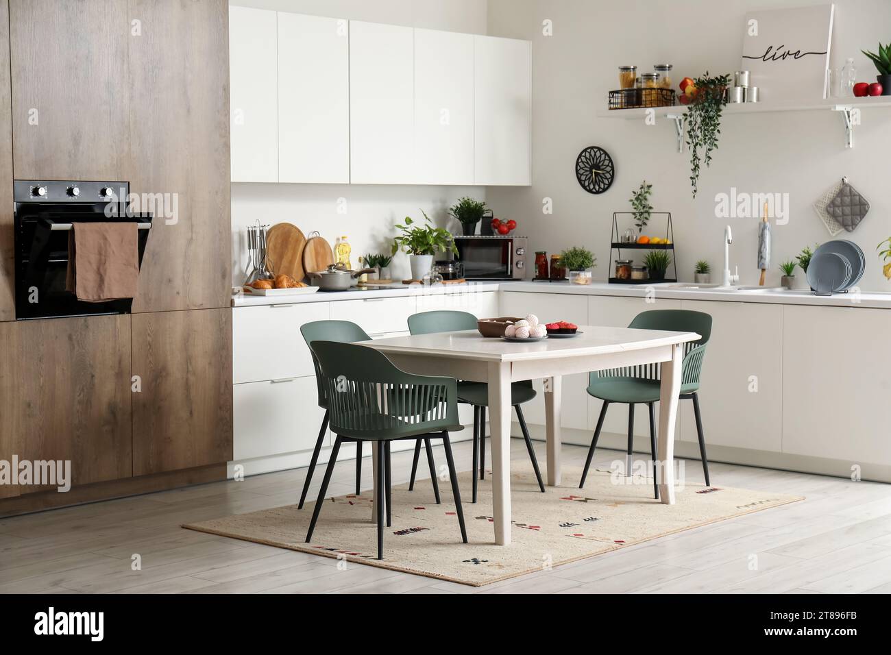 Interior of modern kitchen with white dining table Stock Photo - Alamy