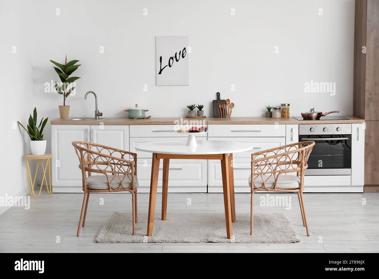 Interior of modern kitchen with pastry on dining table Stock Photo - Alamy