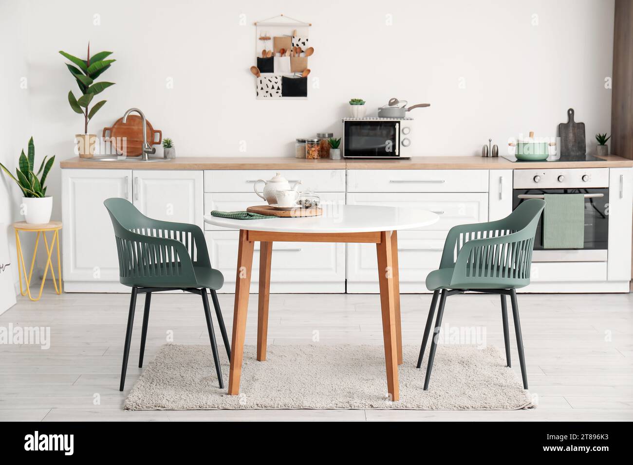 Interior of modern kitchen with teapot and cup on dining table Stock ...