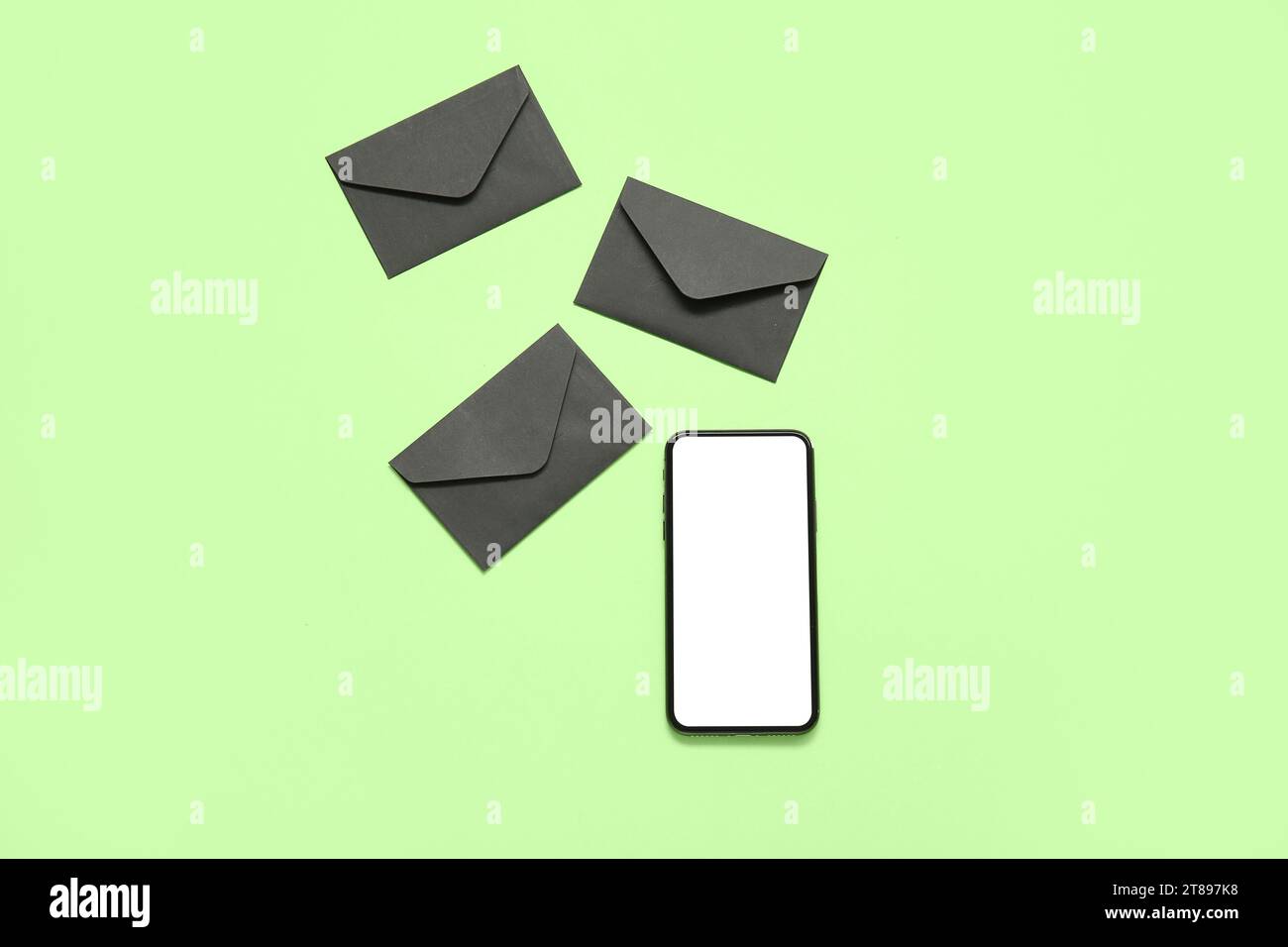 Mobile phone with blank screen and envelopes on green background Stock ...