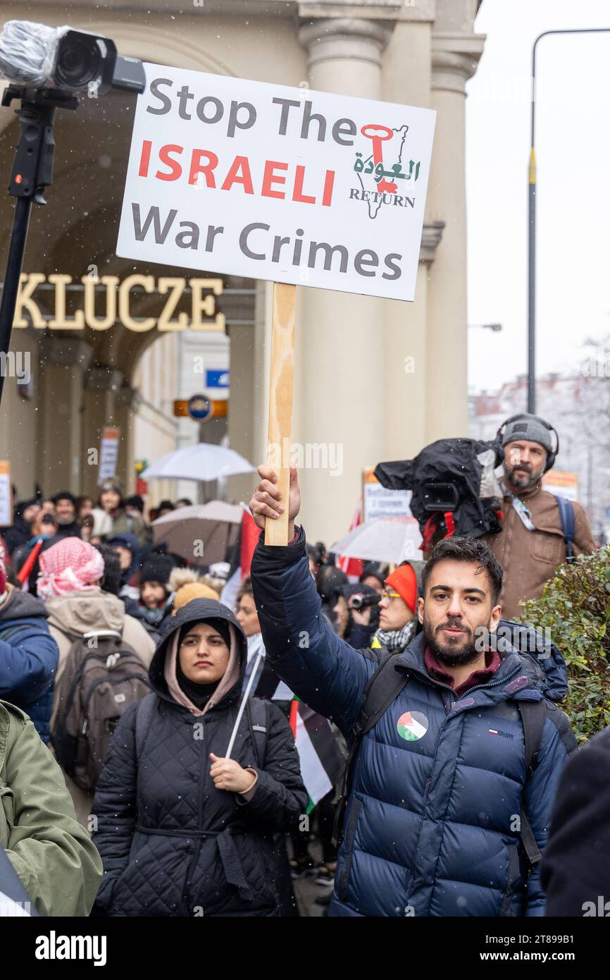 A man holds a banner that says: STOP THE ISRAELI WAR CRIMES. At the ...