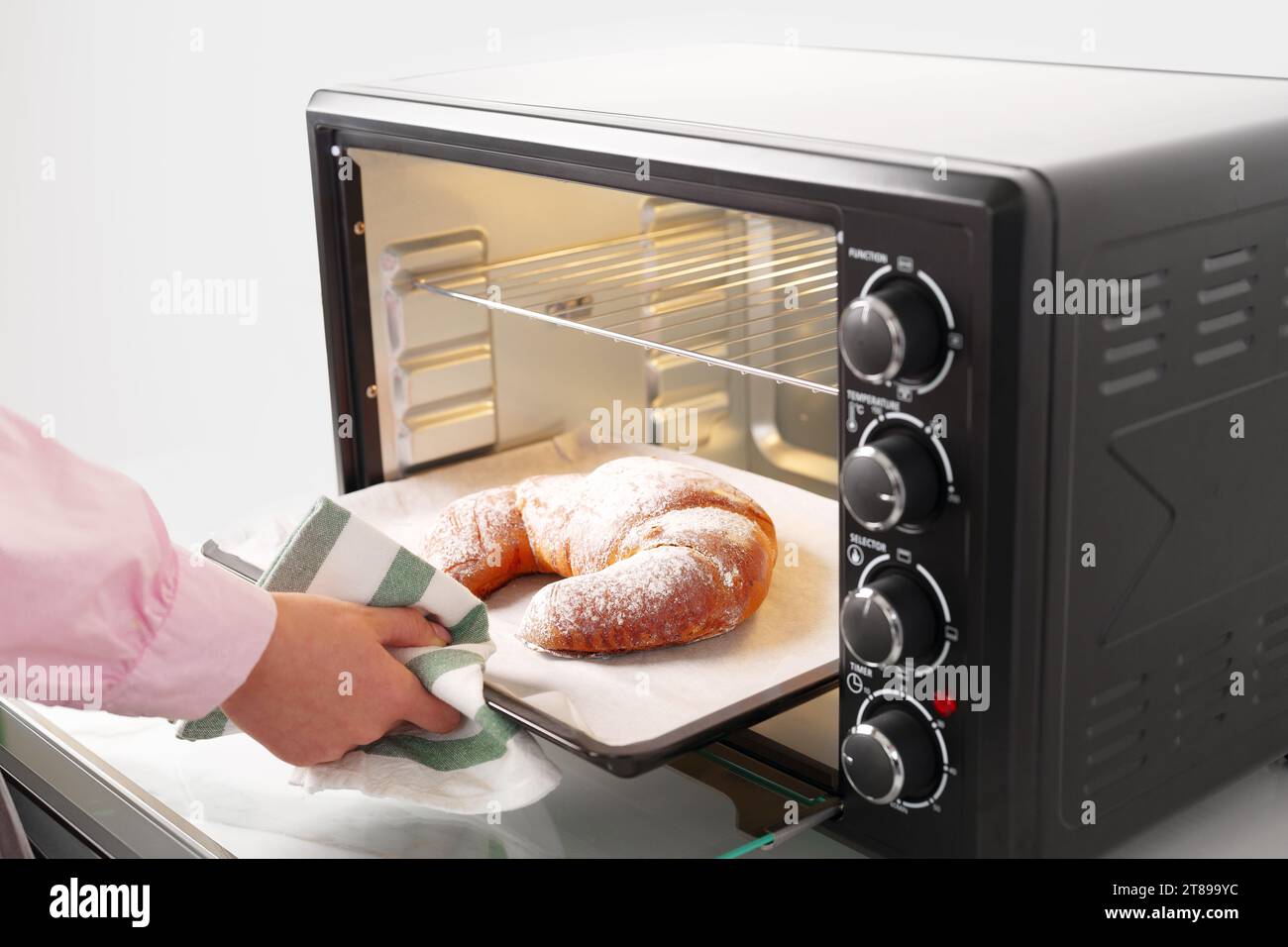 Woman's hands taking fresh bakery out of mini oven Stock Photo - Alamy