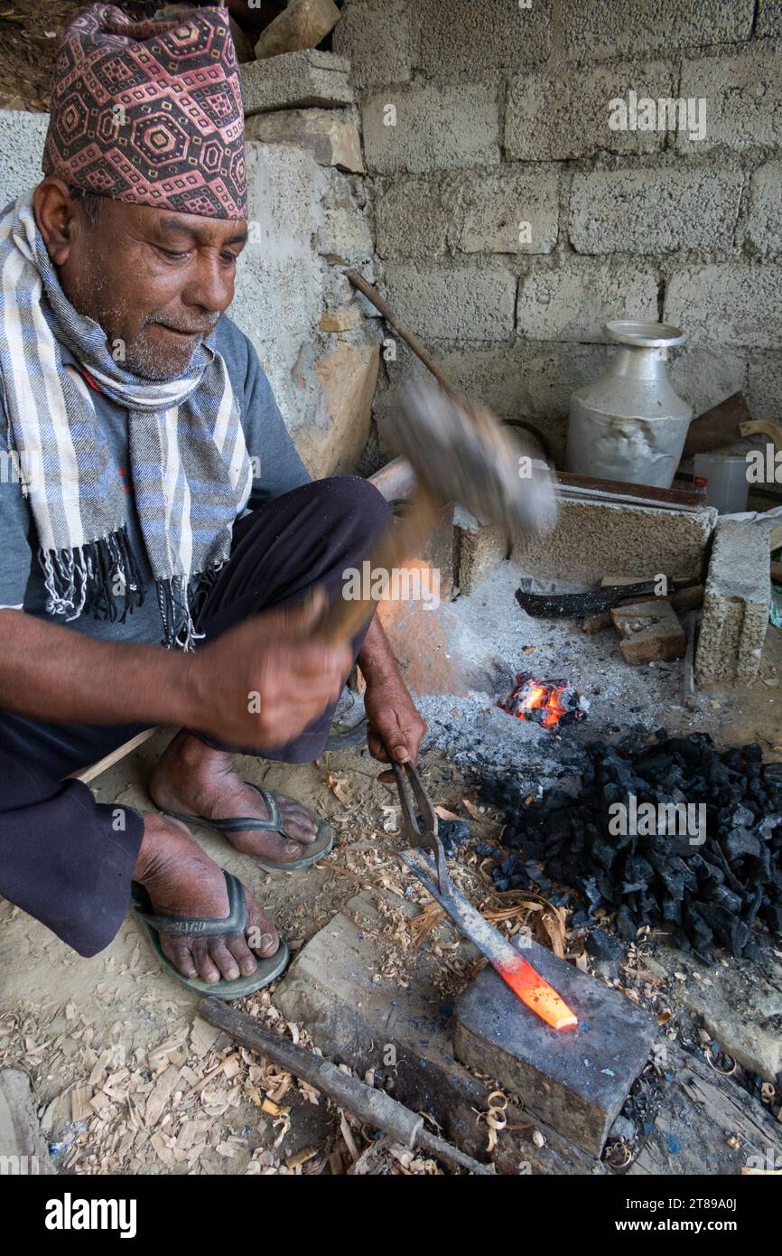 Nepalese blacksmith hammers on red-hot steel to make agricultural tools ...