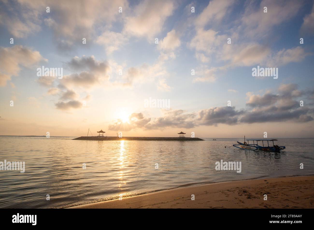 Sunrise at the sandy beach of Sanur. Temple in the water. Traditional ...