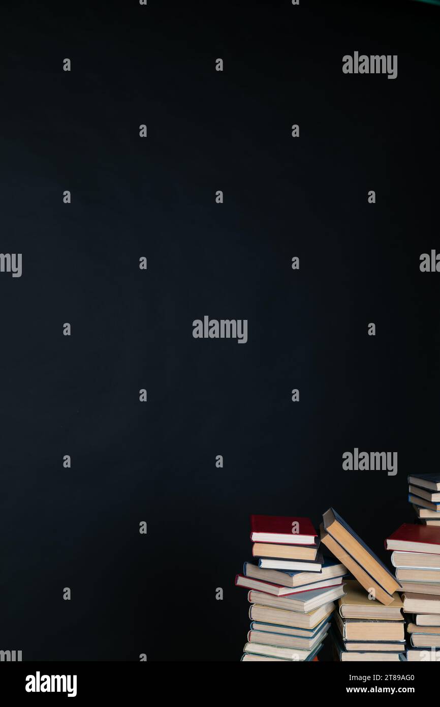 large number of books stacked on a black background in the library ...