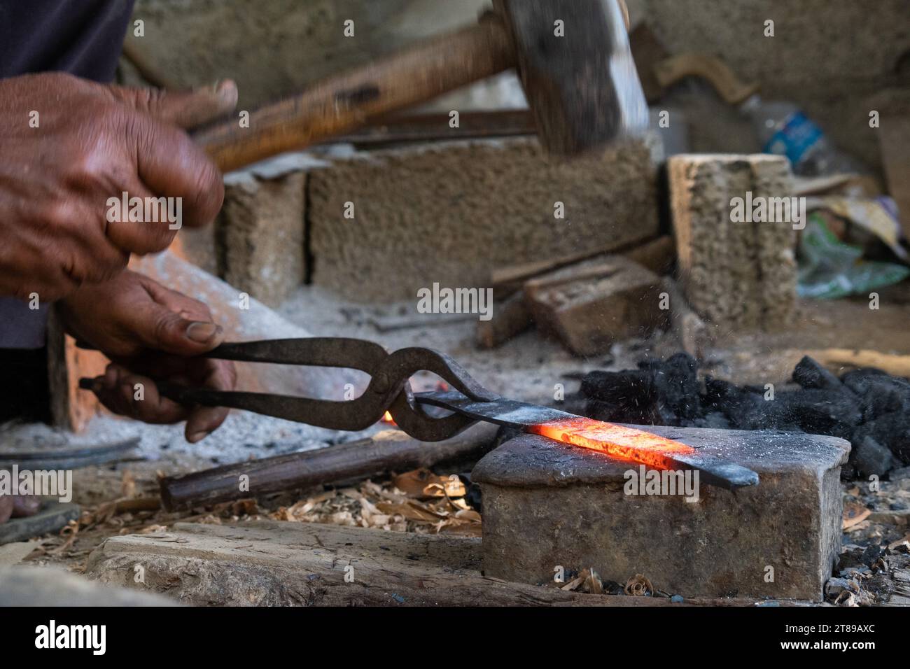 Nepalese blacksmith hammers on red-hot steel to make agricultural tools ...