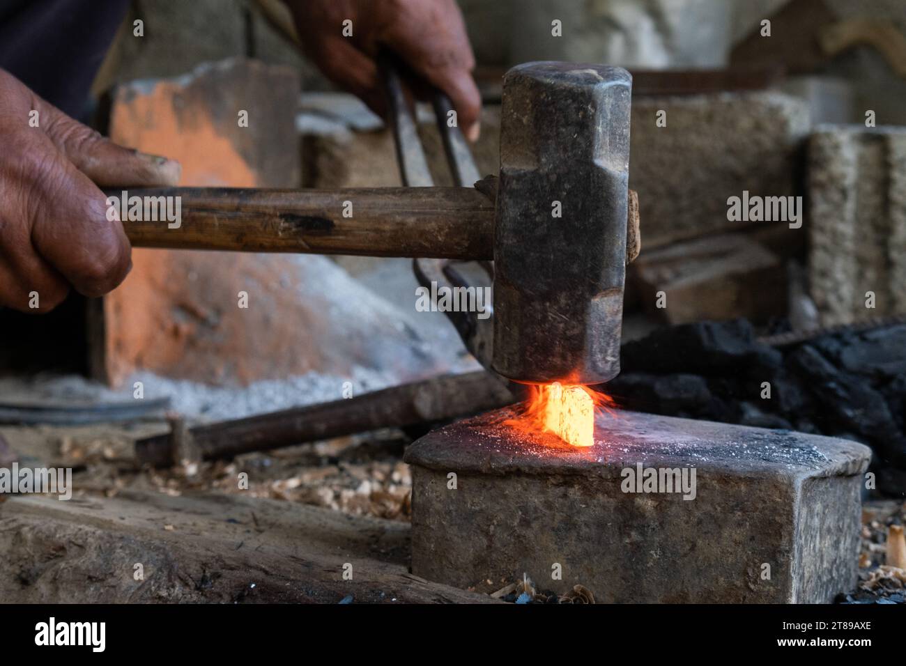 Nepalese blacksmith hammers on red-hot steel to make agricultural tools ...