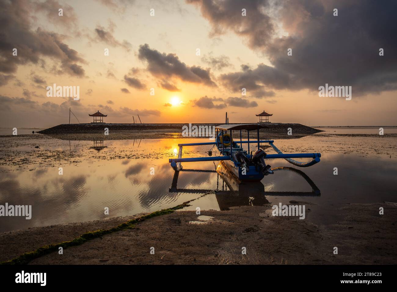 Sunrise at the sandy beach of Sanur. Temple in the water. Traditional ...